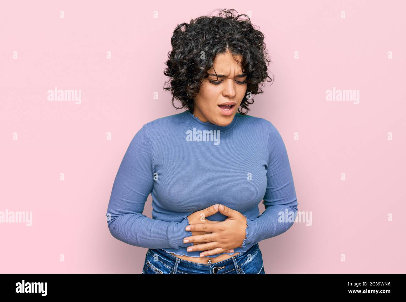 Young hispanic woman with curly hair wearing casual clothes with hand ...