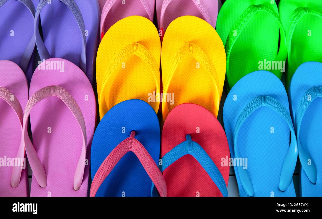 Rows of bright colorful rubber slippers that popular in sand beach and ...