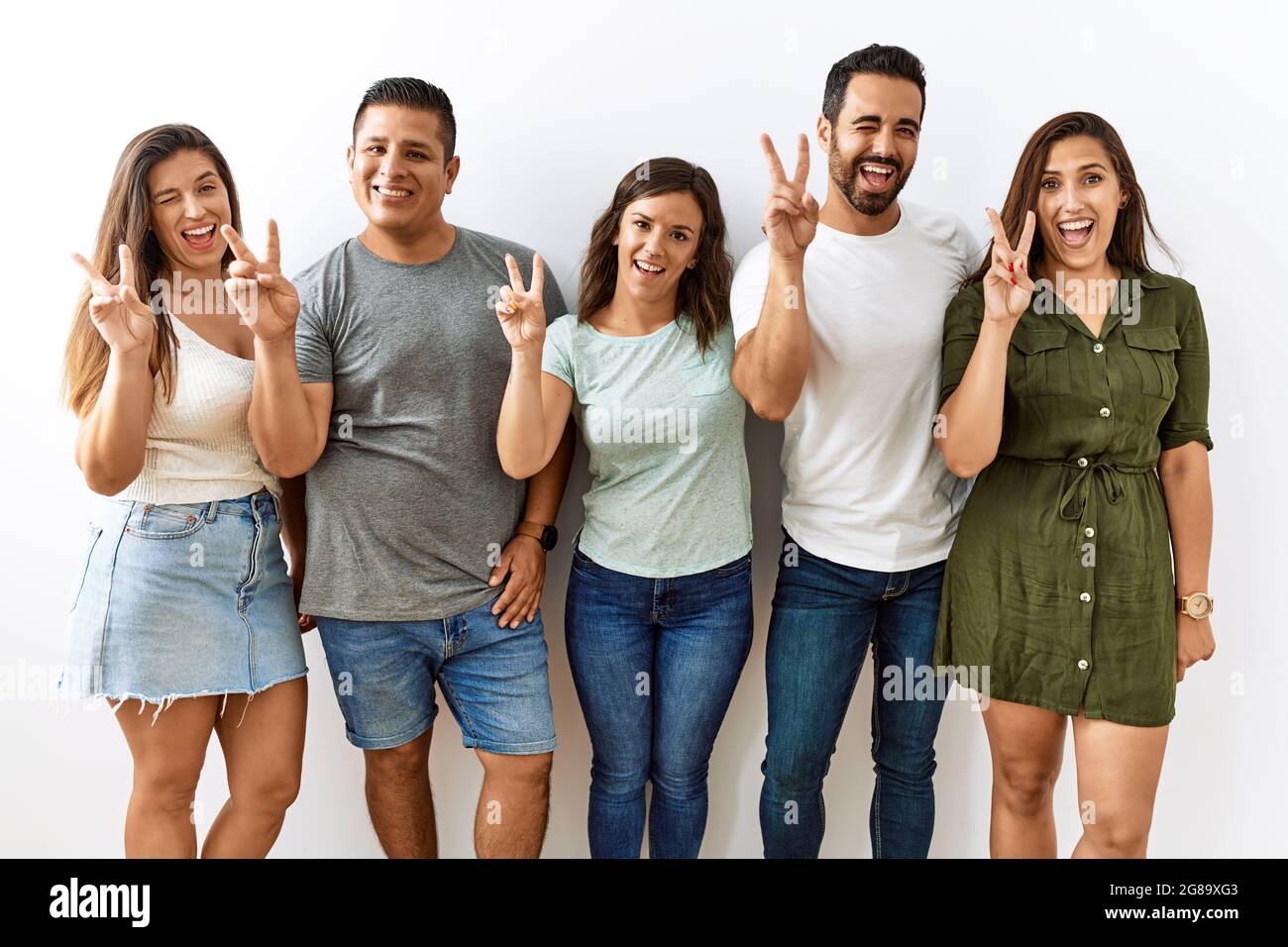 Group of young hispanic friends standing together over isolated ...
