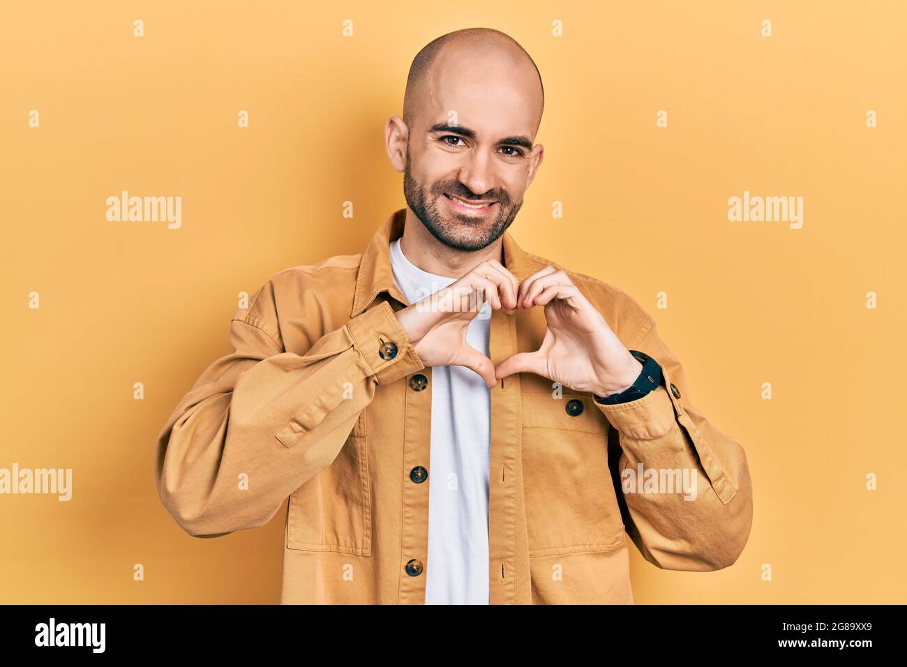 Young bald man wearing casual clothes smiling in love showing heart ...