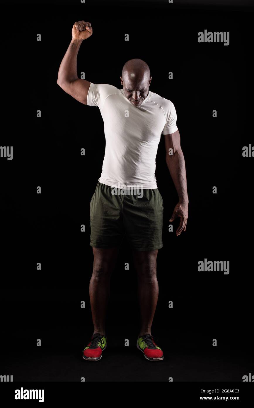 Black male standing with one arm raised and fist clenched while looking ...