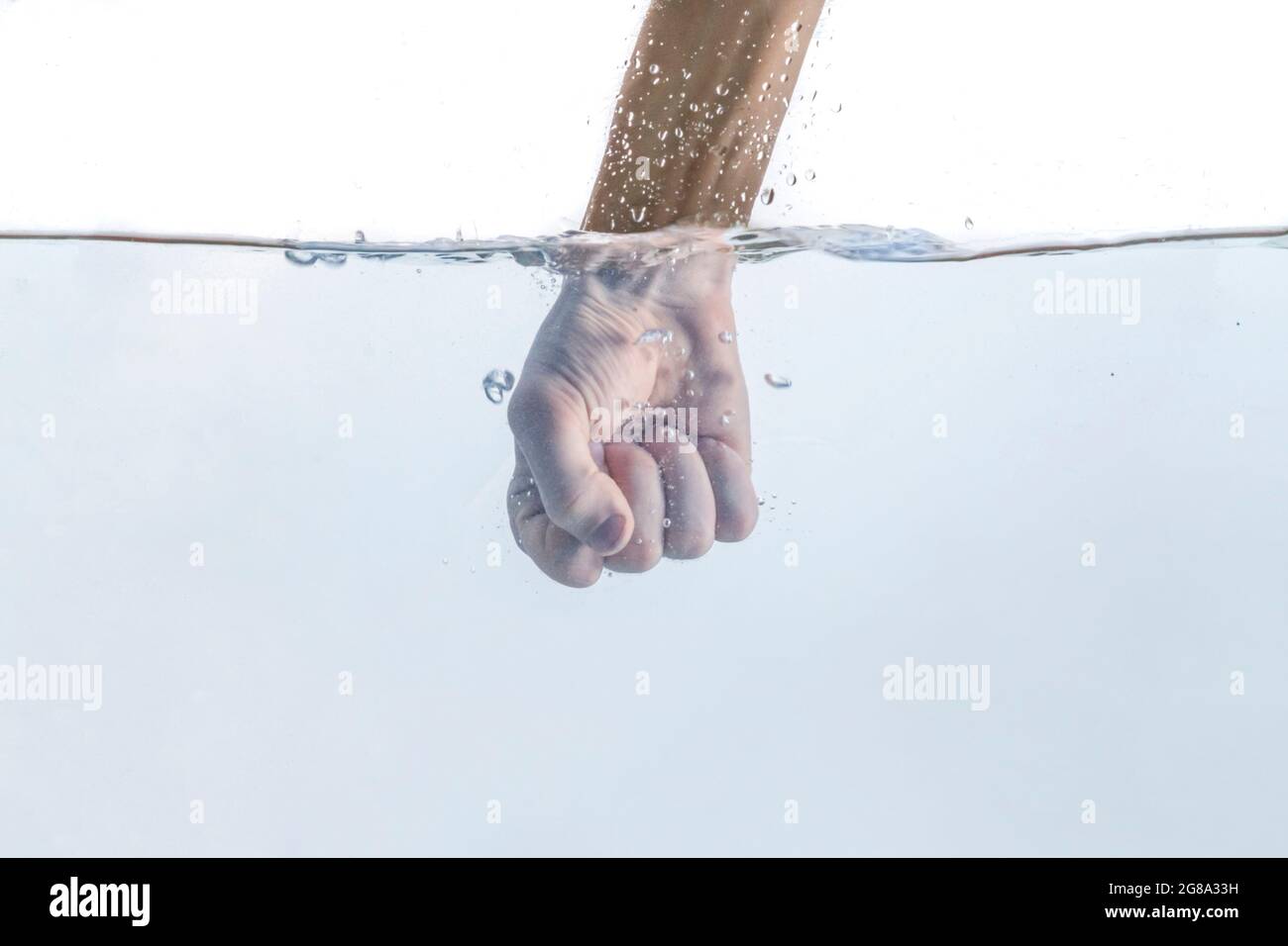 the male fist hand attack punch through the water surface, strength ...