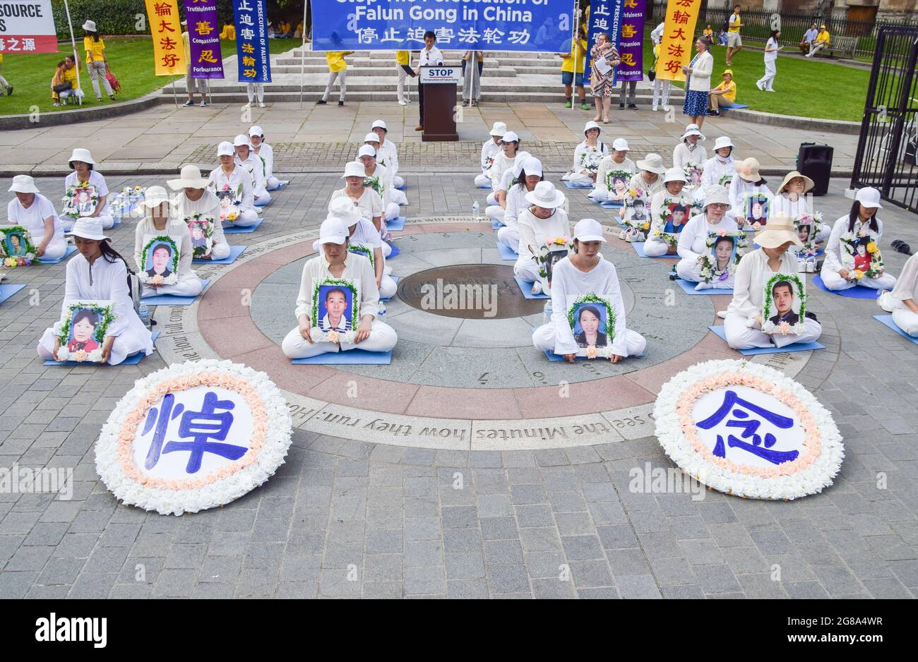 London, UK. 18th July, 2021. Falun Gong demonstrators hold pictures of ...