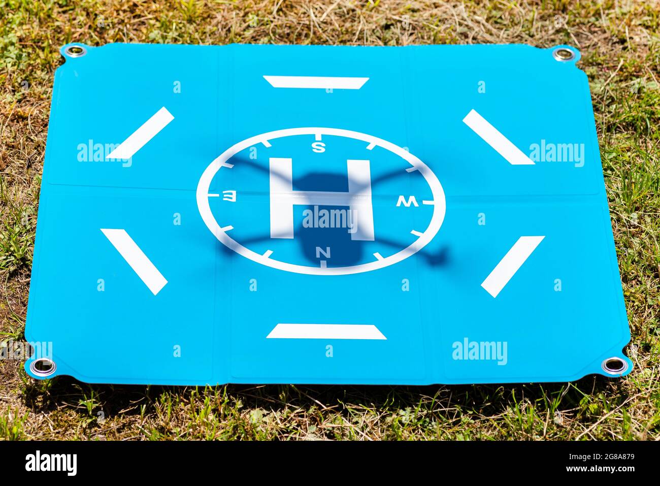 The shadow of the drone taking off is visible on the blue landing pad ...