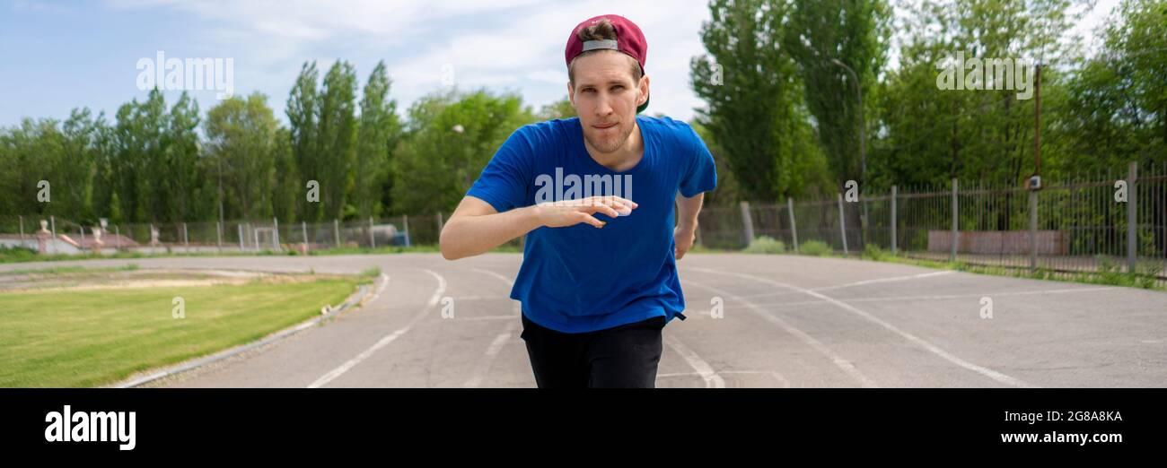 close up head portrait of a man running on a stadium track, fast speed ...