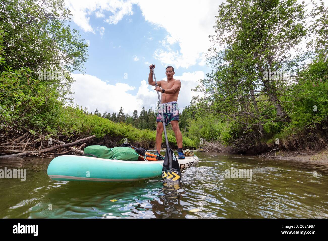Adventurous people paddle boarding in a river Stock Photo - Alamy
