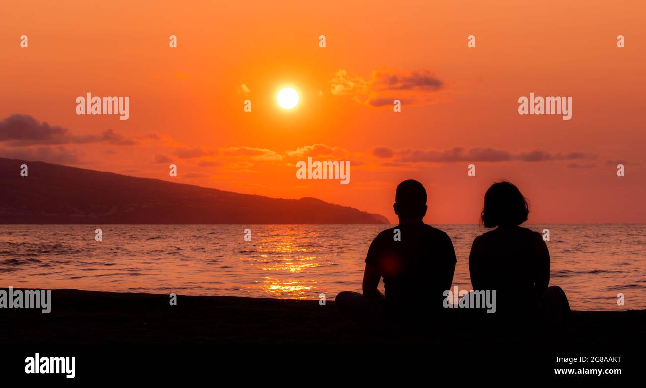 Silhouette couple sitting sunset hi-res stock photography and images ...