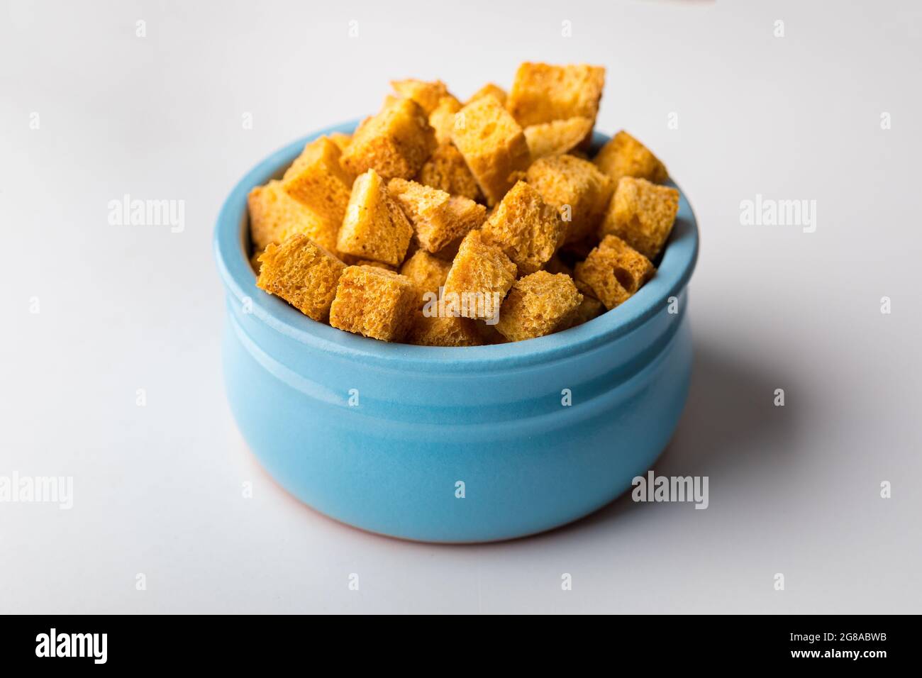 Square-shaped bread crumbs in a blue pot on a white background. Oven ...