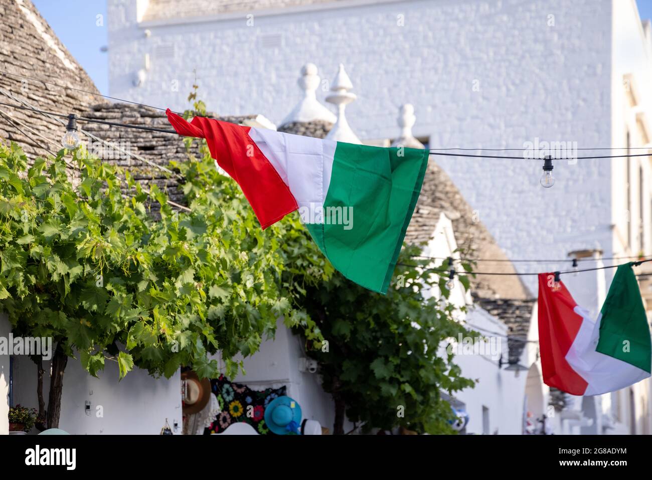 Beautiful town of Alberobello with italian flag and typical trulli ...