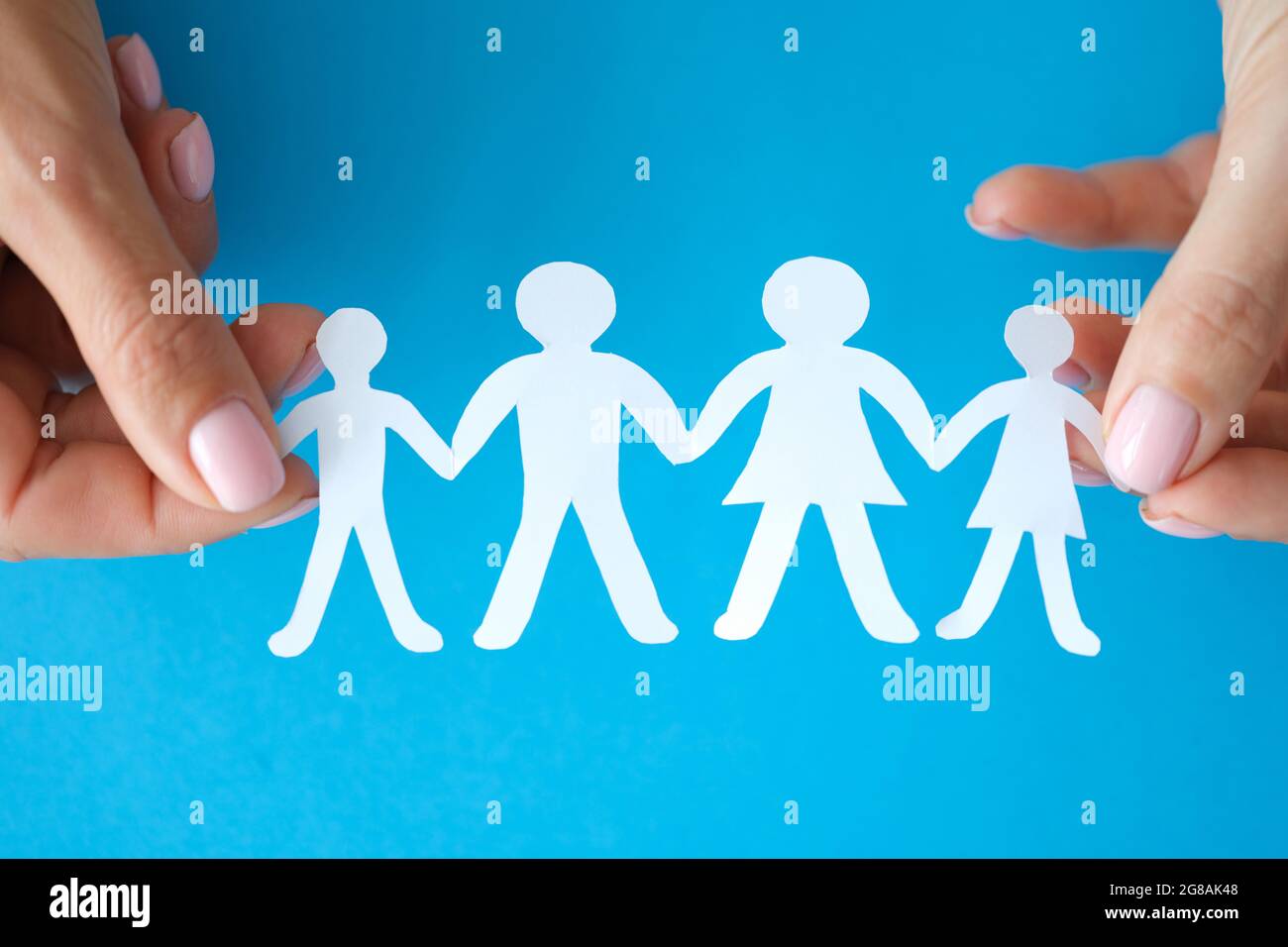 Female hands showing family of paper figures closeup Stock Photo - Alamy