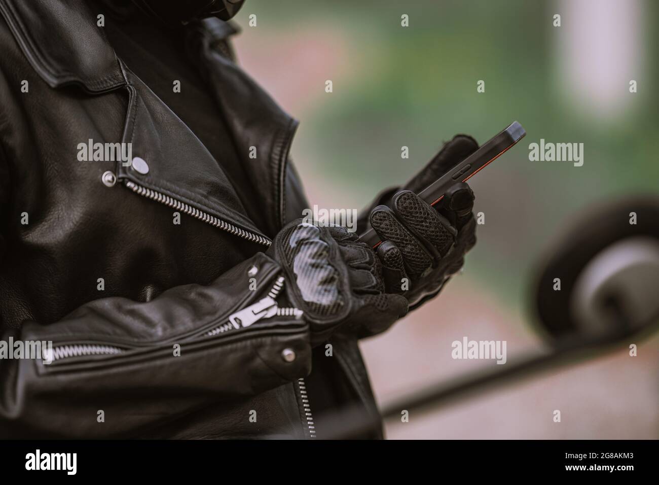 Portrait of motorcyclist woman using mobile phone, smartphone during ...