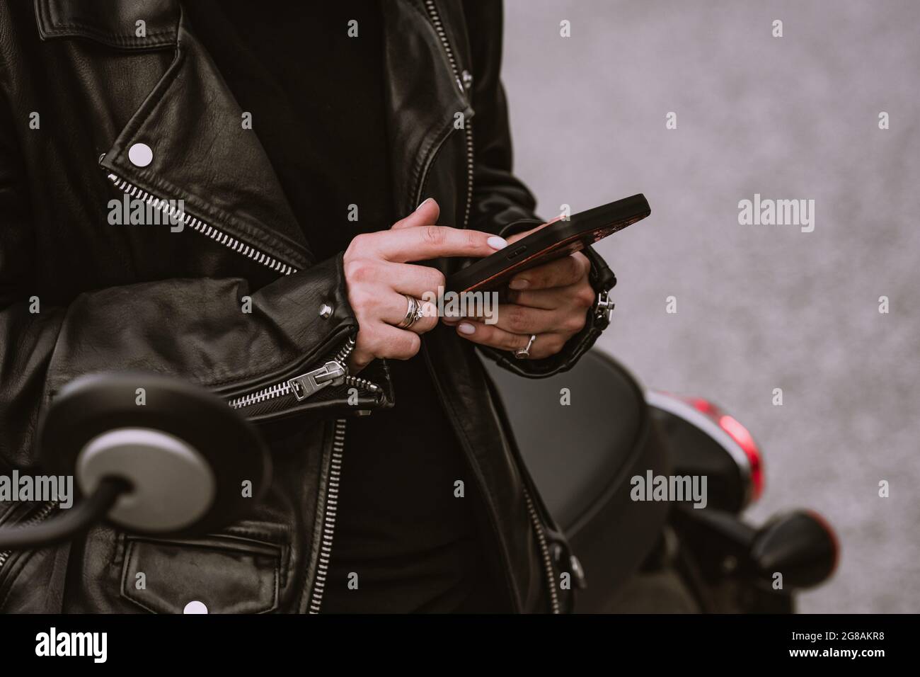 Portrait of motorcyclist woman using mobile phone, smartphone during ...