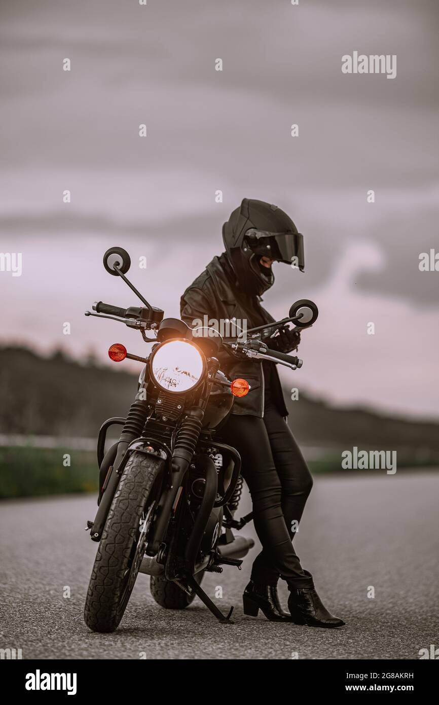 Portrait of motorcyclist woman using mobile phone, smartphone during ...