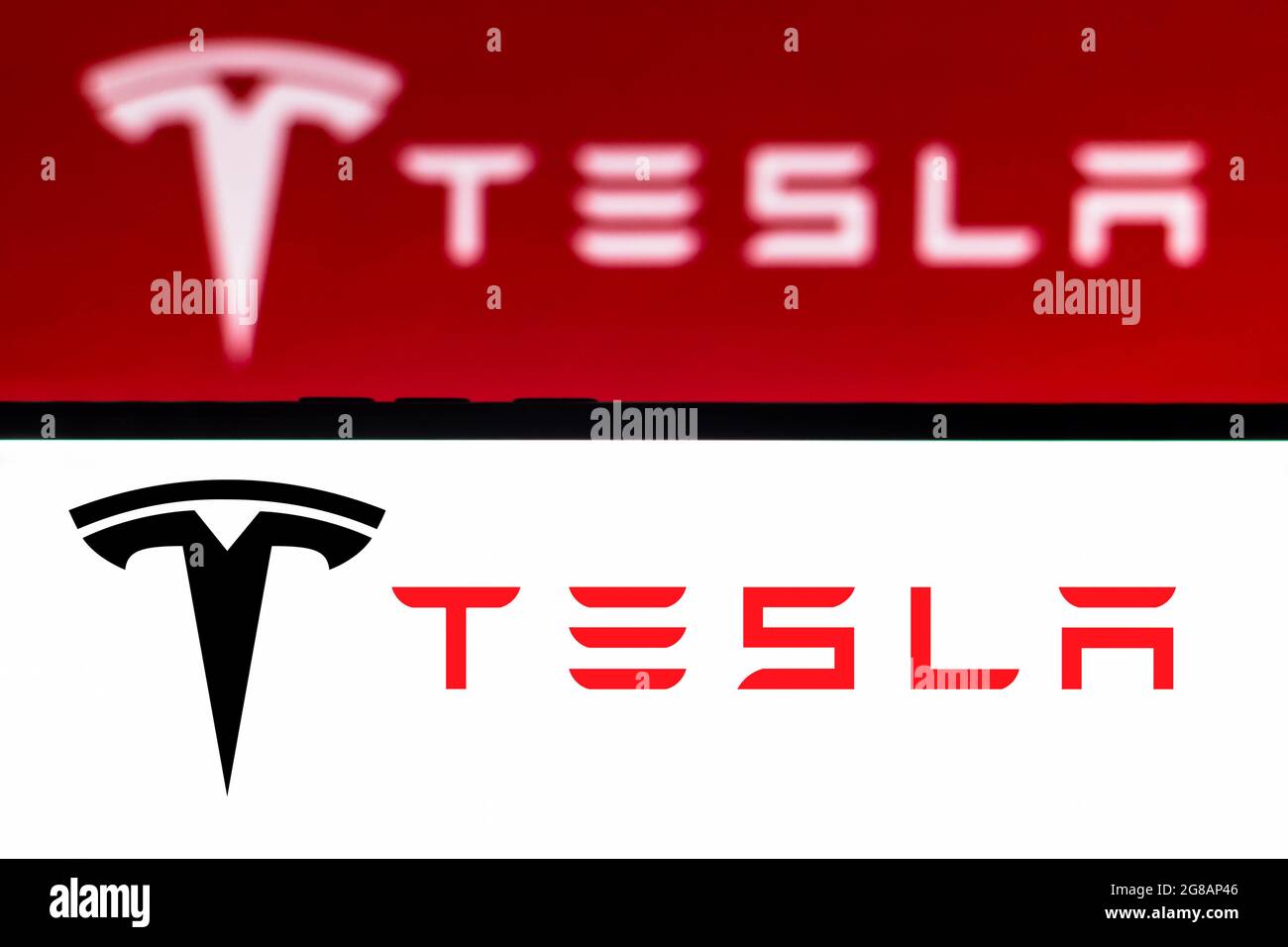 In this photo illustration the Tesla logo is seen on a smartphone and a ...