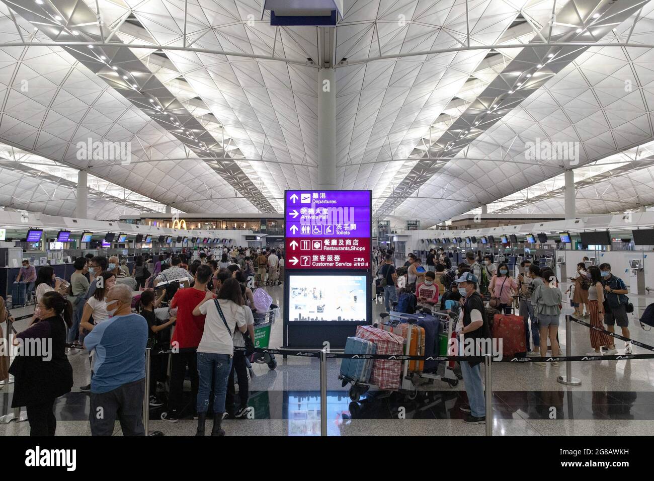 People waiting in the check-in queue for their departure, at Hong Kong ...
