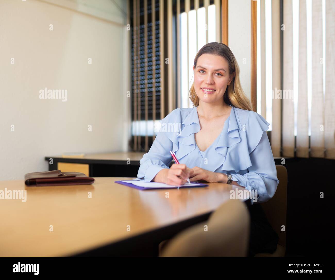 Business woman in office interior filling up documents Stock Photo - Alamy