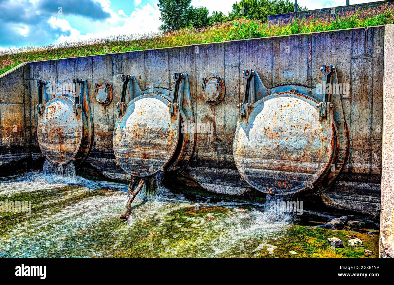 Heavy metal flood control gate discharging into a waterbody Stock Photo ...