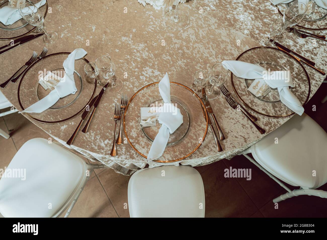 High angle shot of empty glass plates on a round table in a restaurant ...