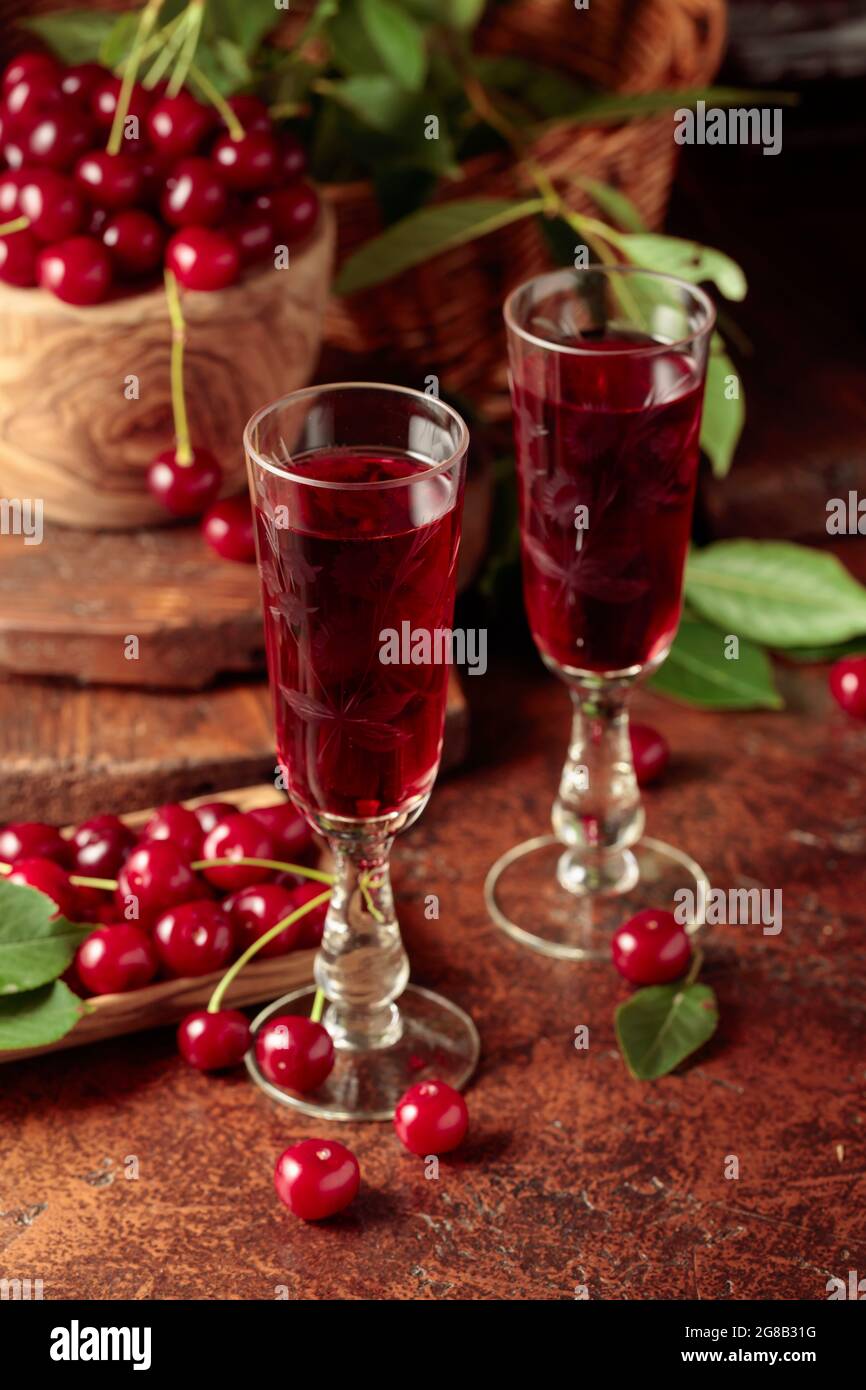 Cherry liquor and ripe juicy berries on a brown table Stock Photo - Alamy