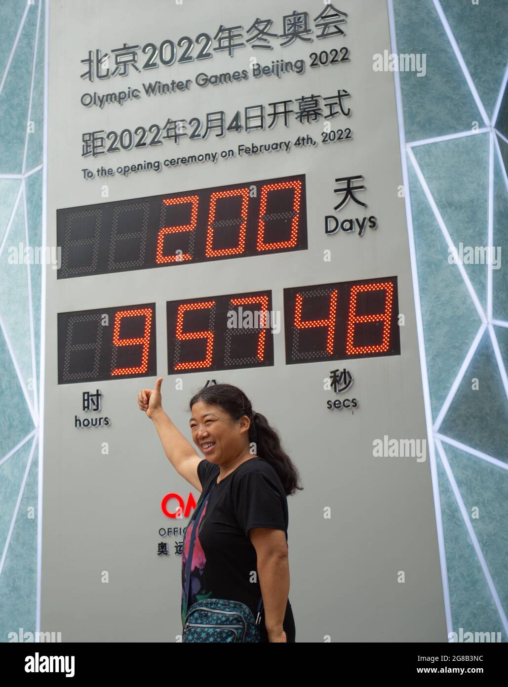 Beijing, China. 19th July, 2021. A tourist poses in front of a ...