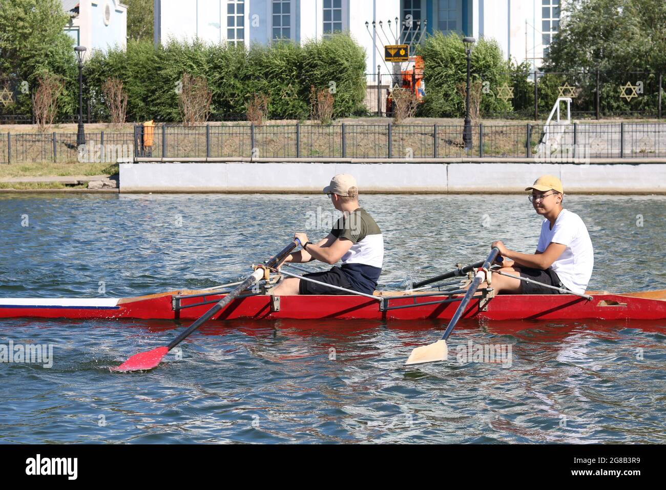 Young rowers holding paddles in boats, city background Stock Photo - Alamy
