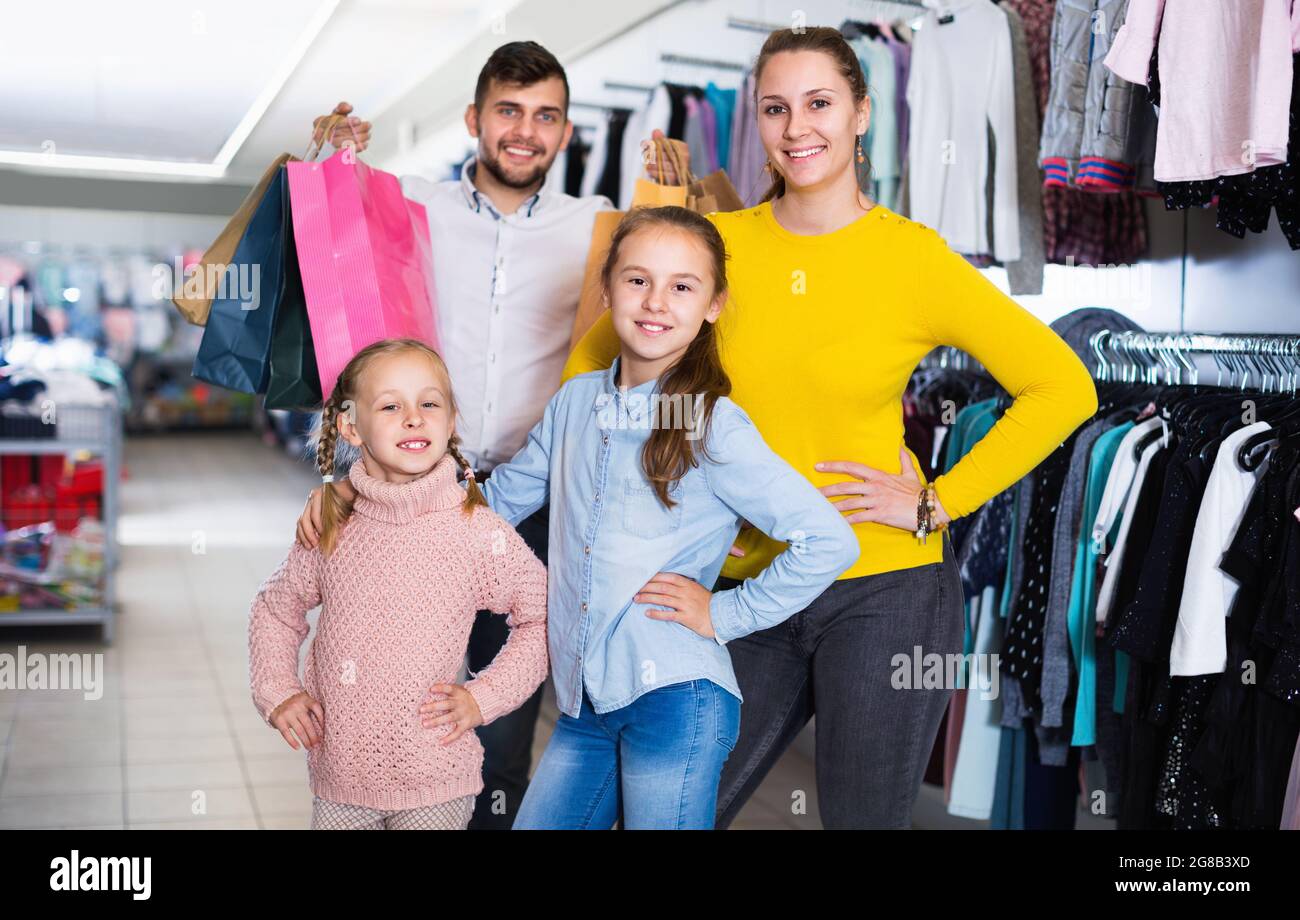 Portrait of happy young woman, two little girls and man with shopping ...