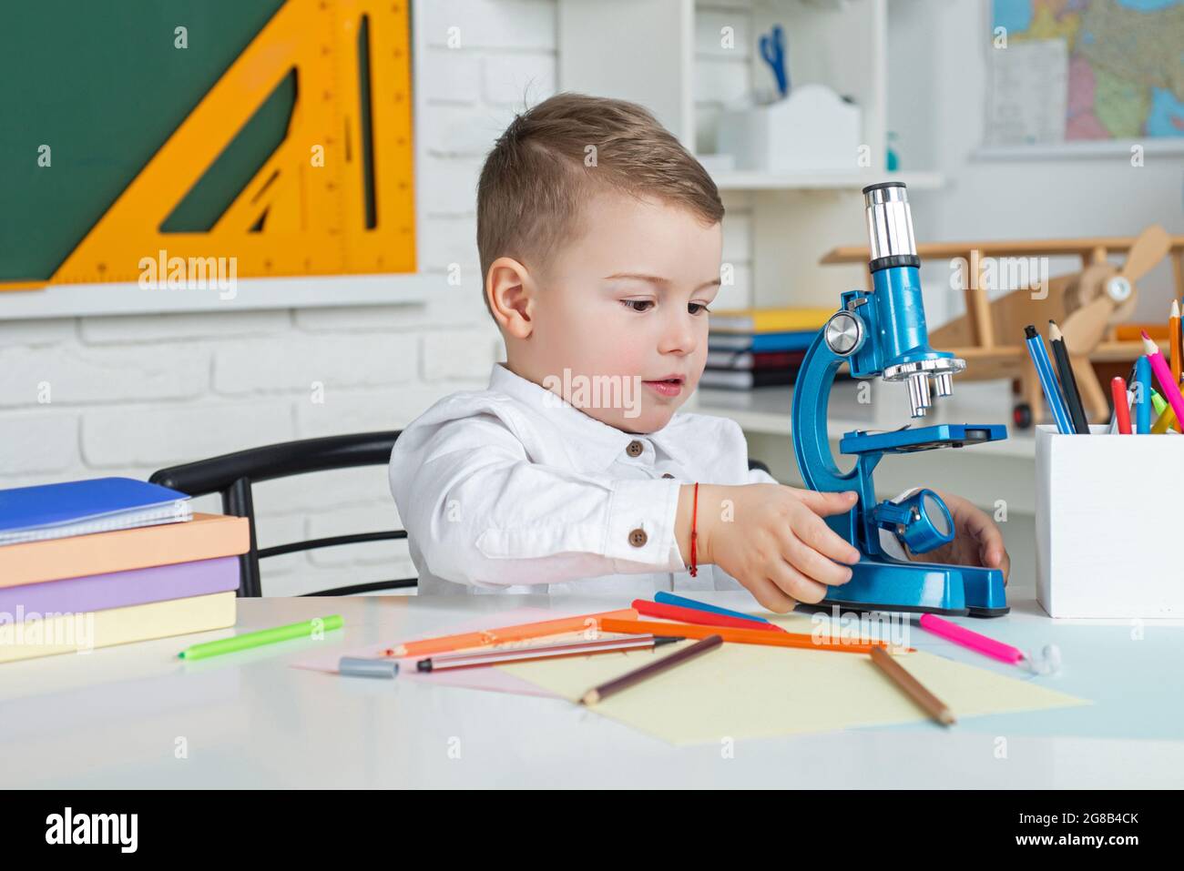 Kid is learning in class on background of blackboard. School kids. Home ...