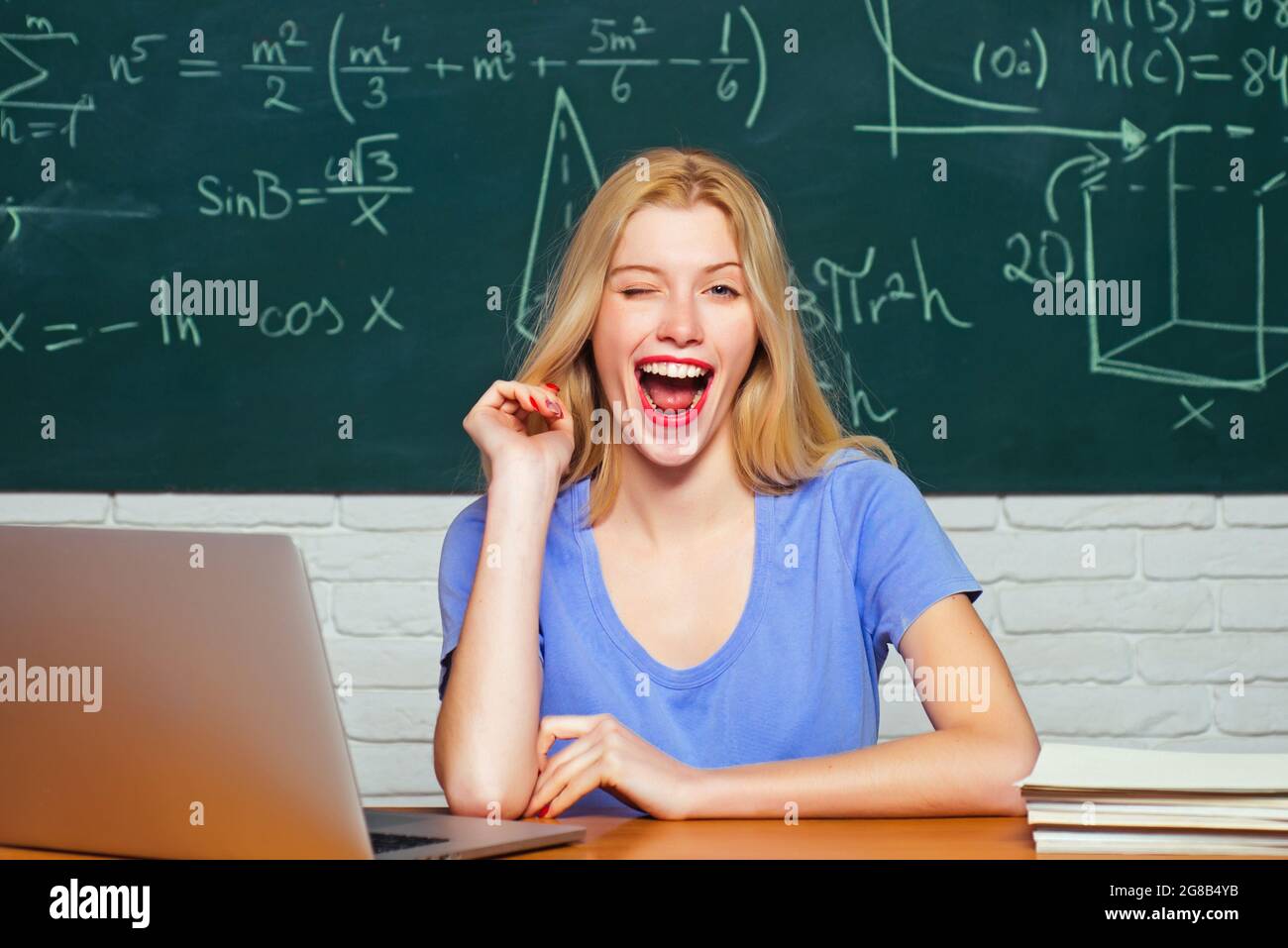 Student girl with happy face expression near desk with school supplies ...