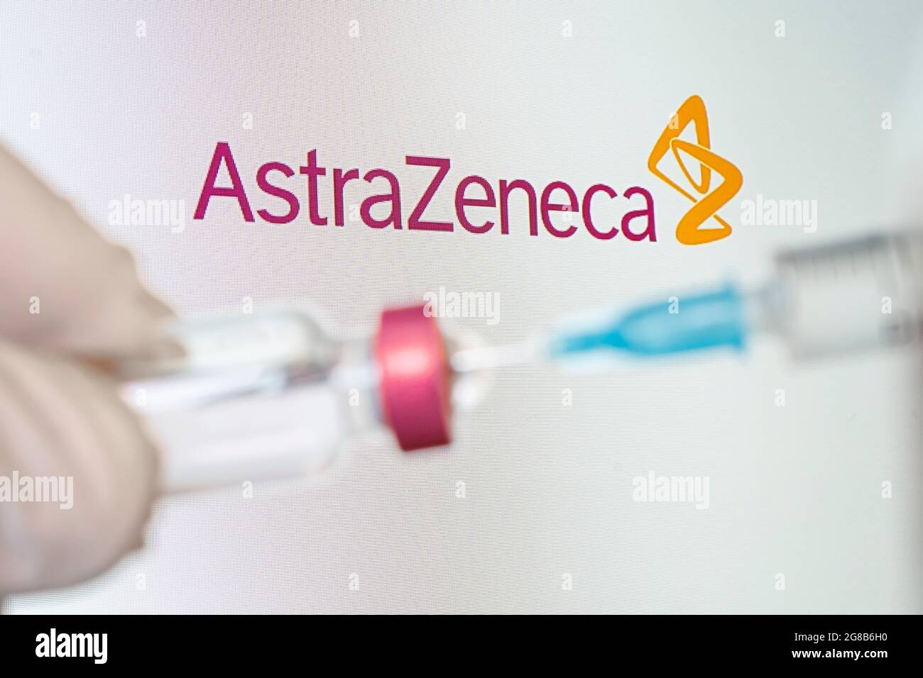 A vaccination syringe and a glass ampoule with a clear liquid on a blue ...