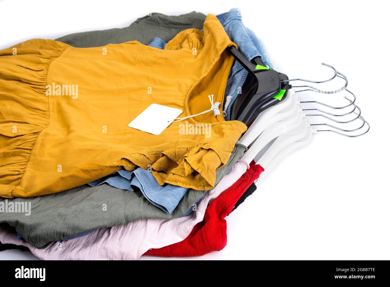 Stack of dresses on hangers on a white Stock Photo - Alamy