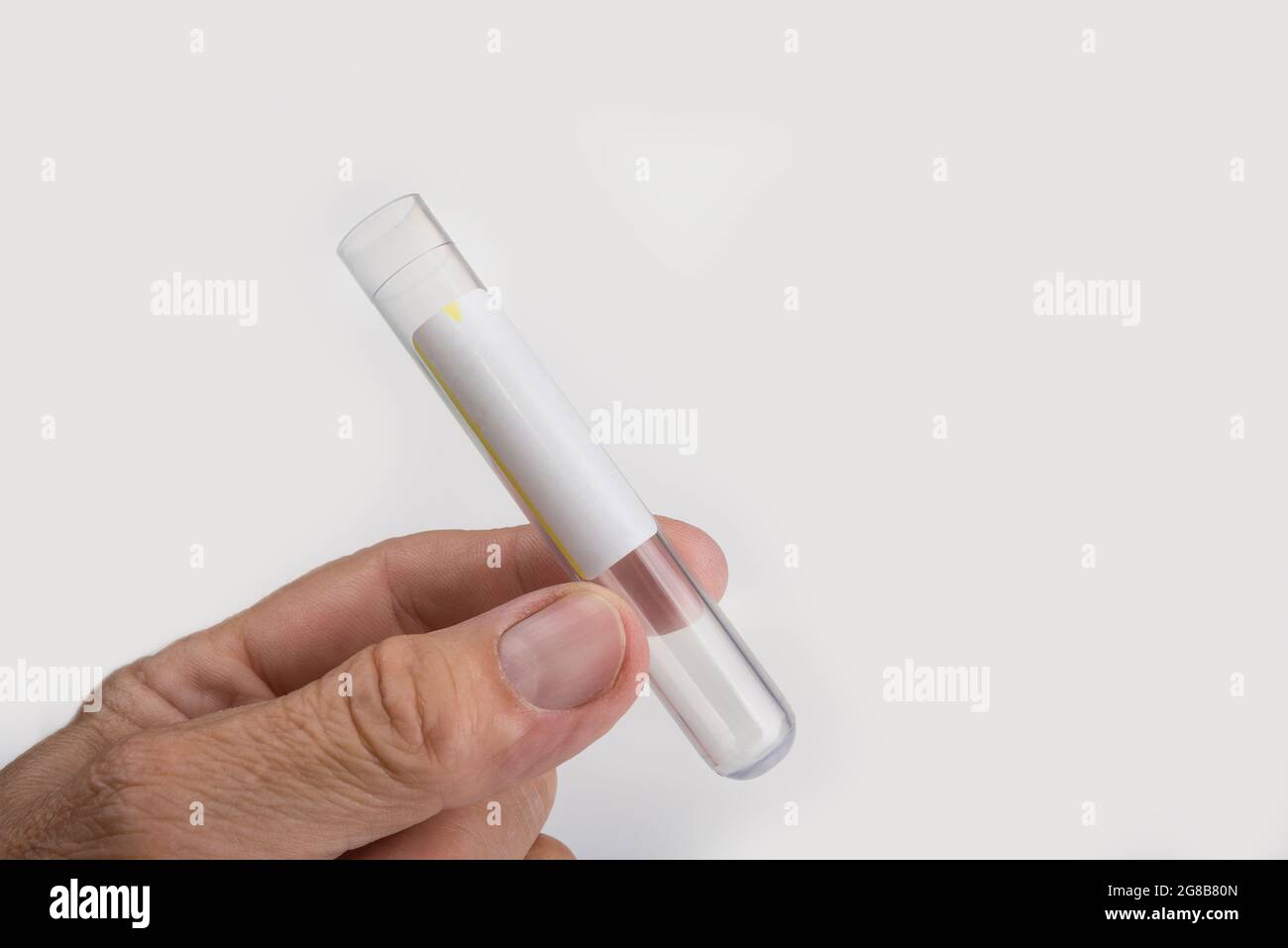 New test tube in the hand on a white Stock Photo - Alamy