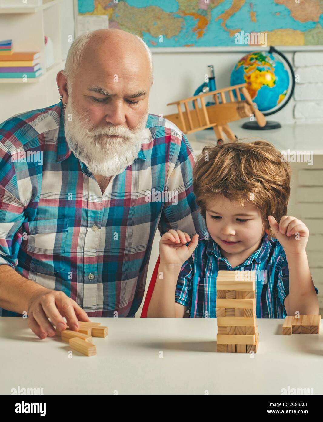 Jenga game at home. Happy three generations of men playing Jenga in ...