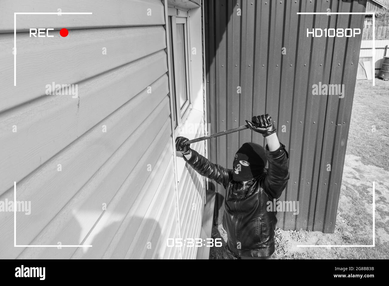 CCTV view of burglar breaking in to home through window with crowbar ...