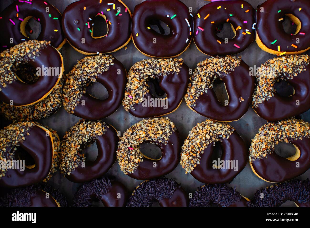 Rows of dark colorful donuts process in fall color style and taken from ...