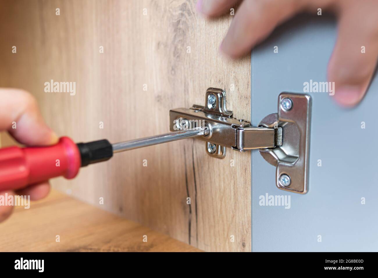 Concept of home repairing. A hand of a furniture assembler adjusting a ...