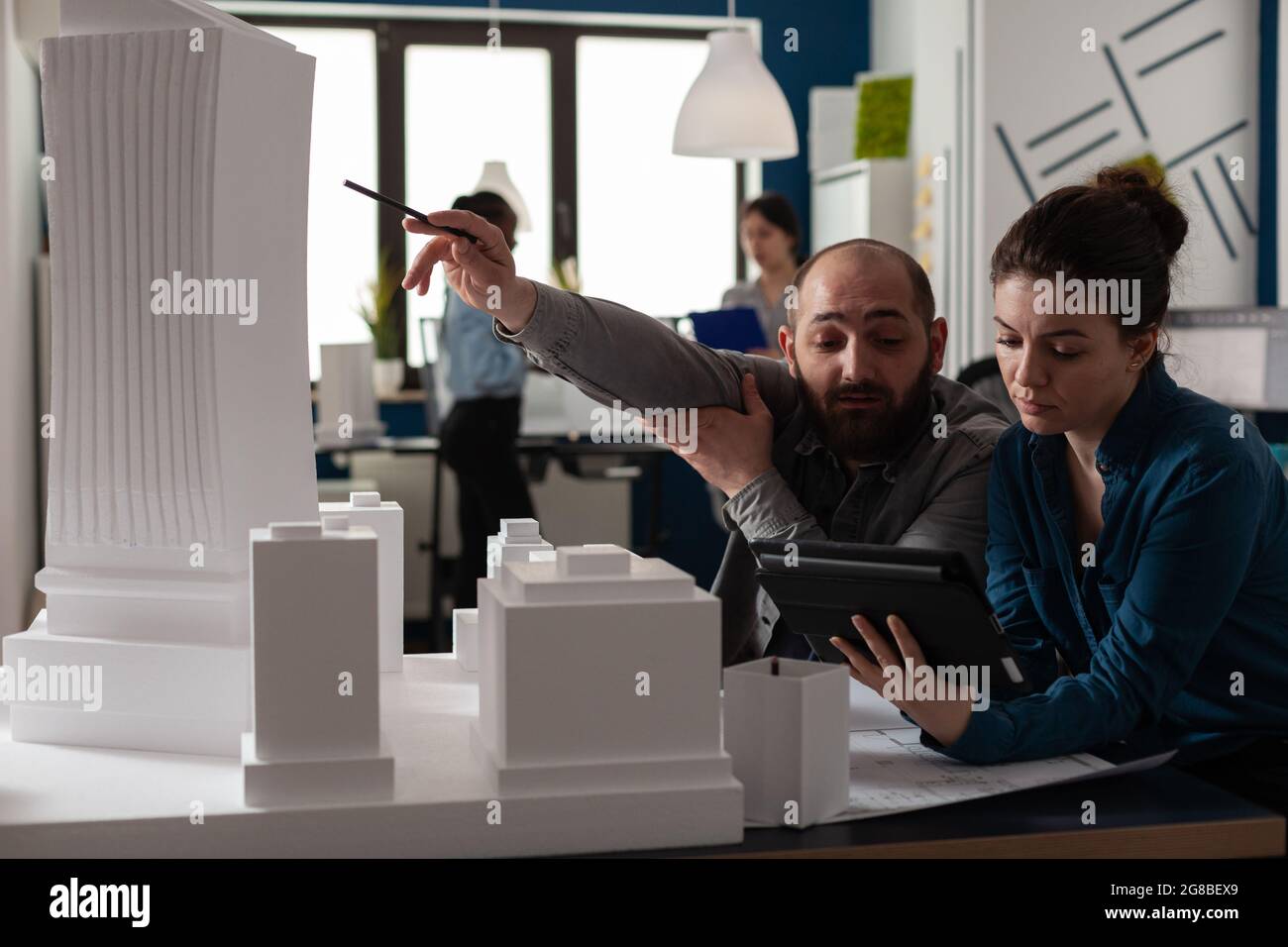 Team of construction architects work on tablet at office to plan ...