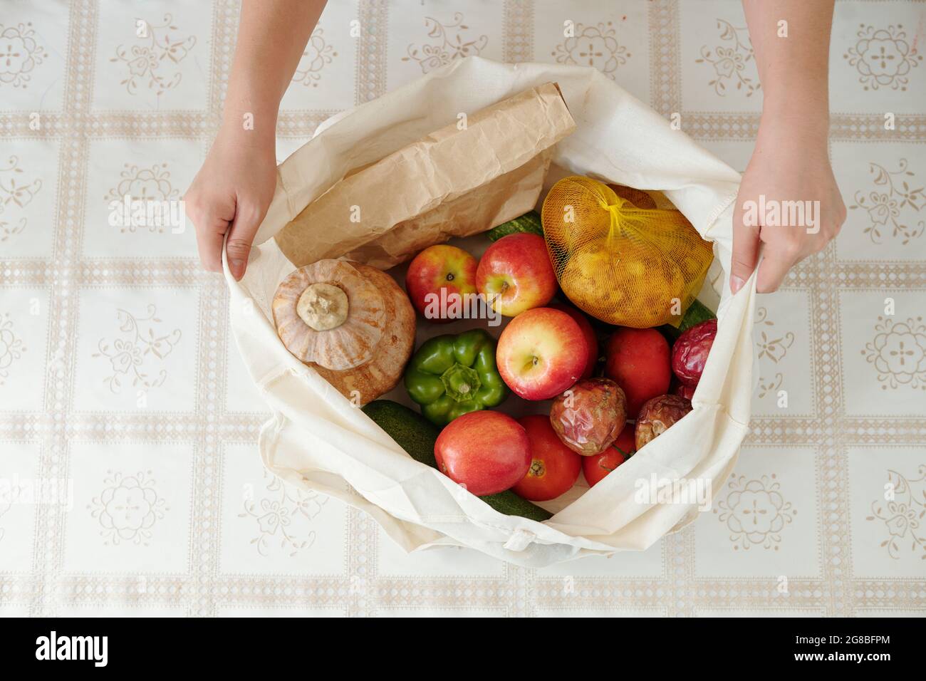 Hands of young woman opening sack of fresh fruits and vegetables, view ...