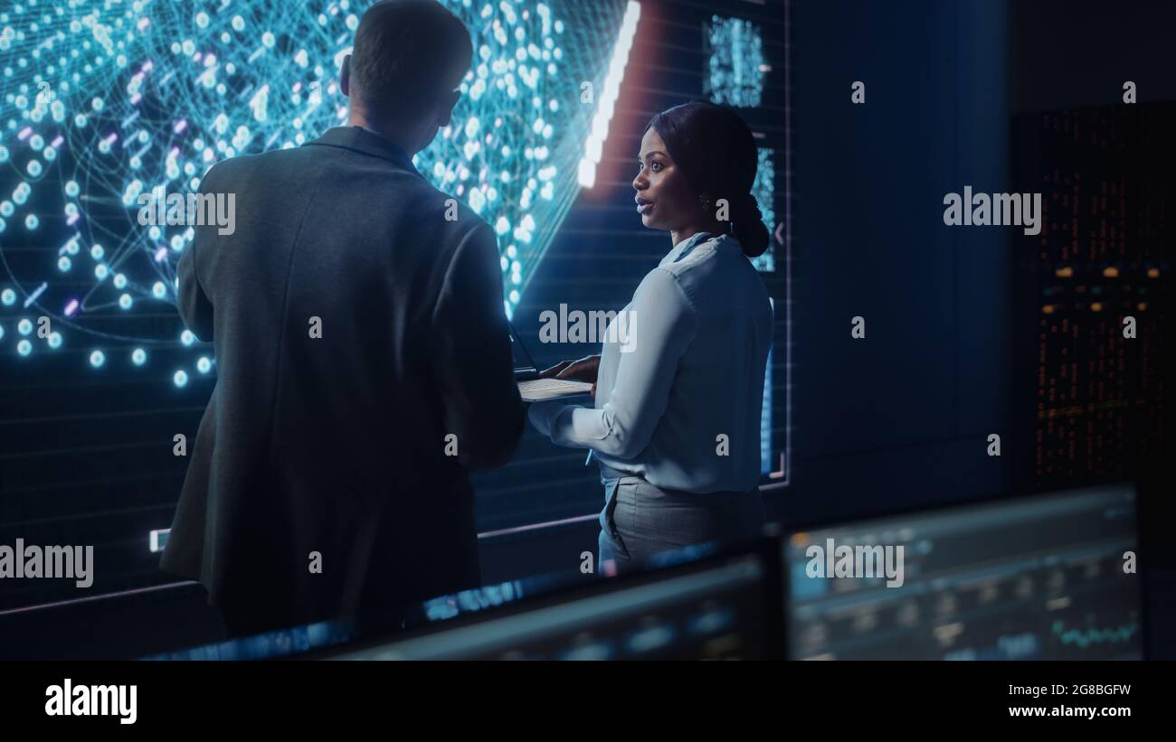 Project Manager and Computer Science Engineer Talking while Using Big Screen Display Showing ...