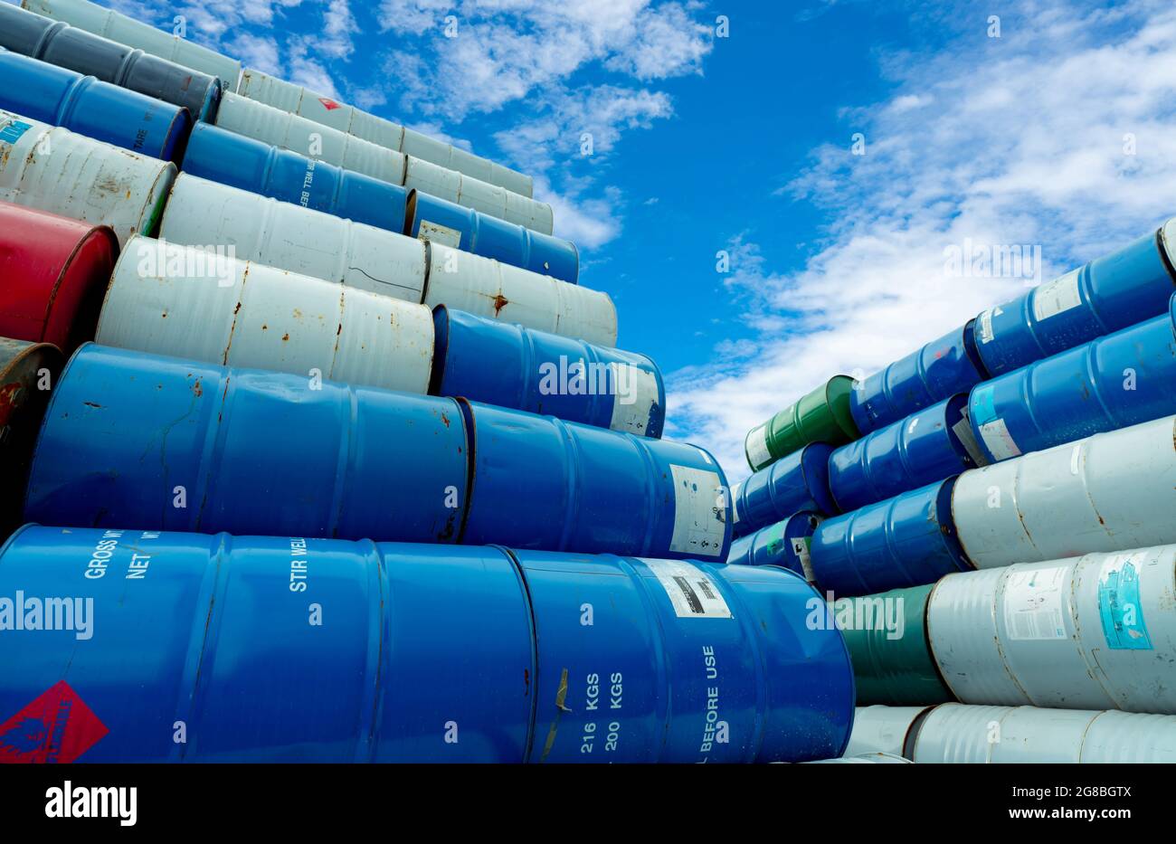 Stack of old chemical barrels. Blue, green, and red oil drum. Steel oil ...