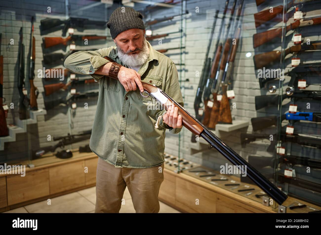 Bearded male hunter loads rifle in gun store Stock Photo - Alamy