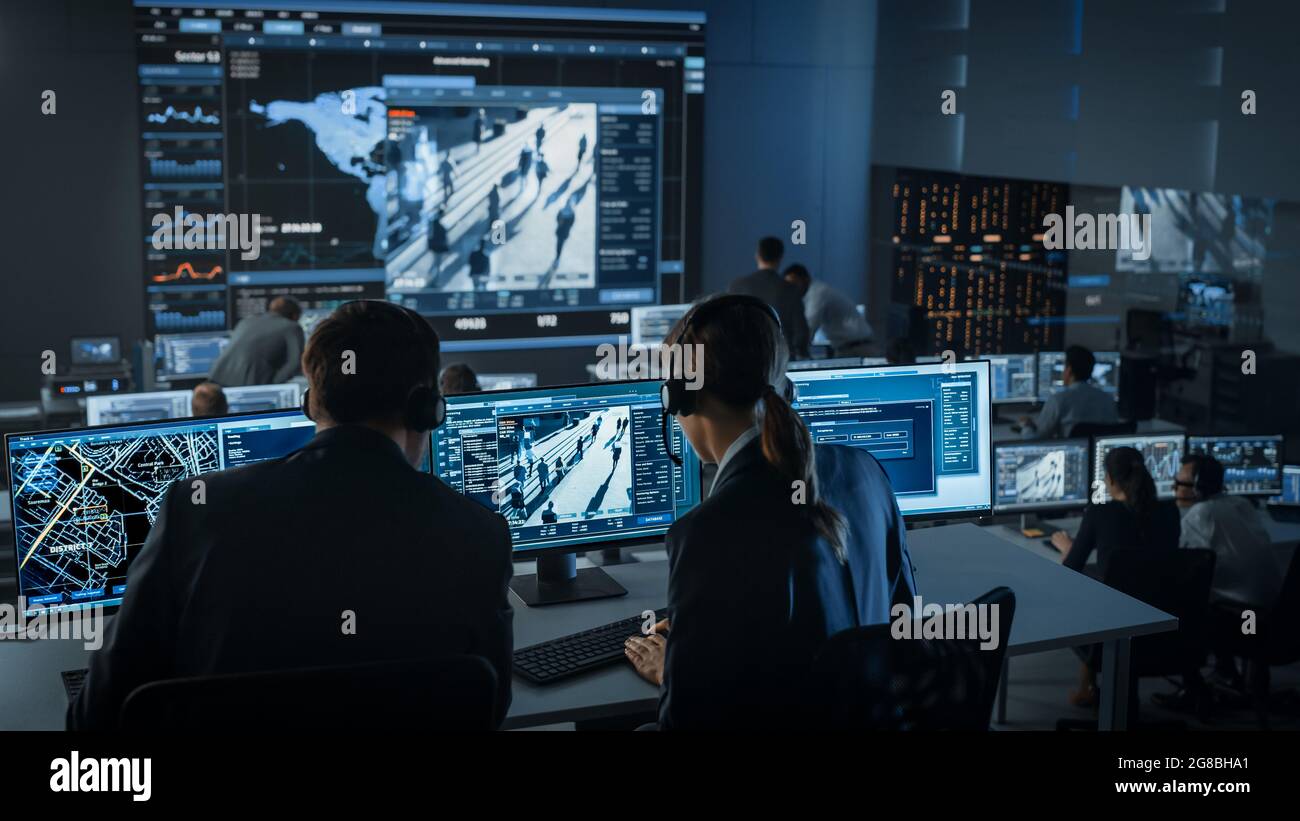 Female Officer Works on a Computer with Surveillance CCTV Video Footage ...