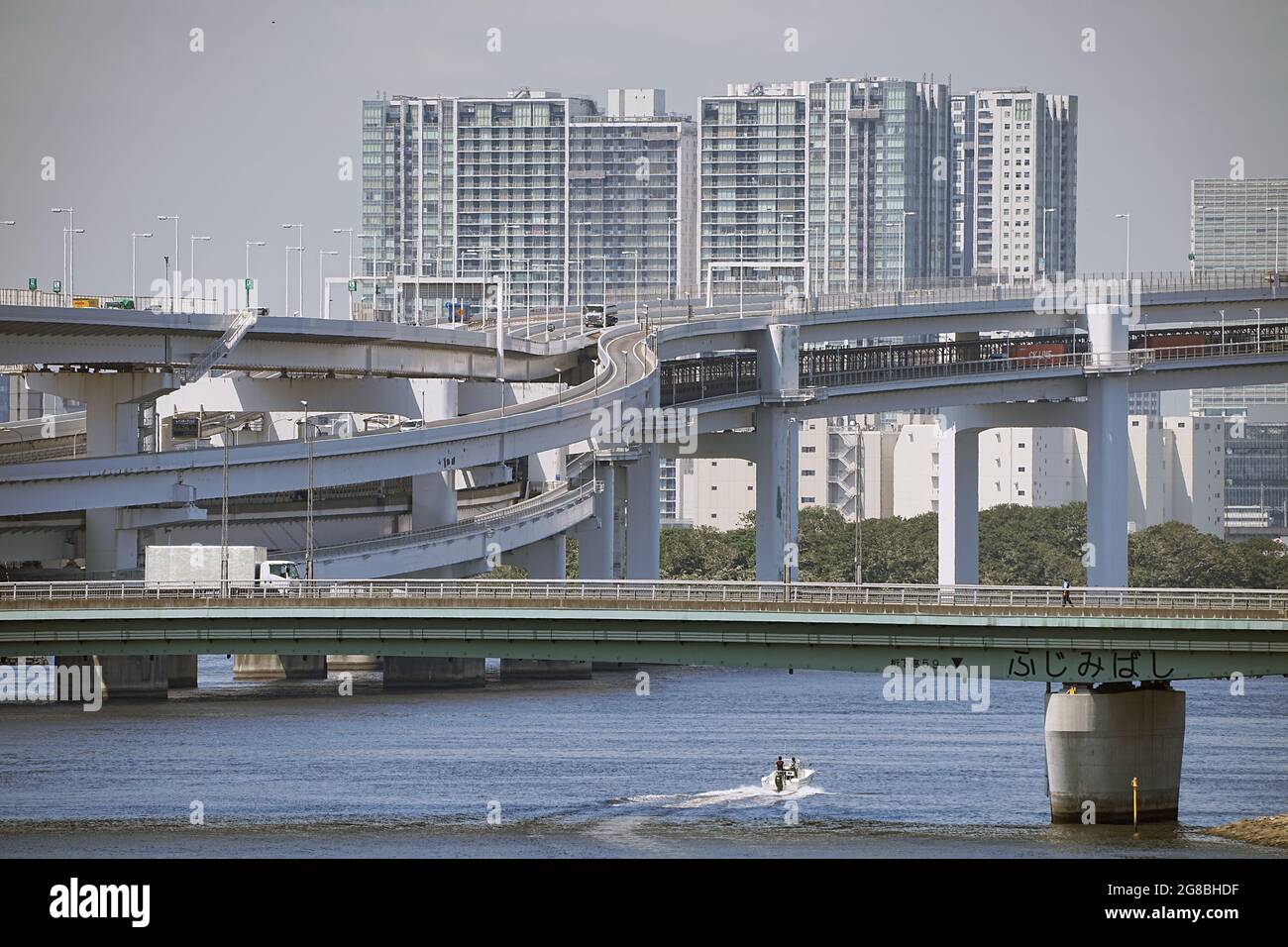 Tokio, Japan. 19th July, 2021. A motorboat passes under a multi-storey ...