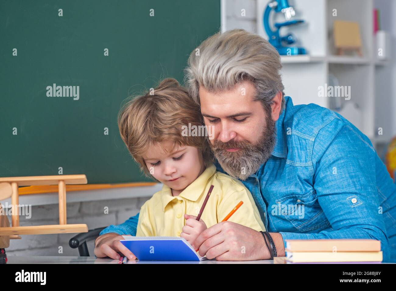 Father and son together schooling. Pupil learning letters and numbers ...