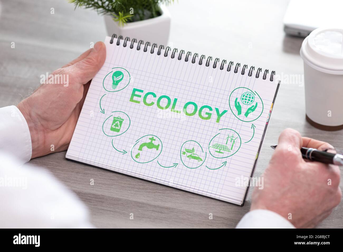 Hand holding a notepad with ecology concept Stock Photo - Alamy