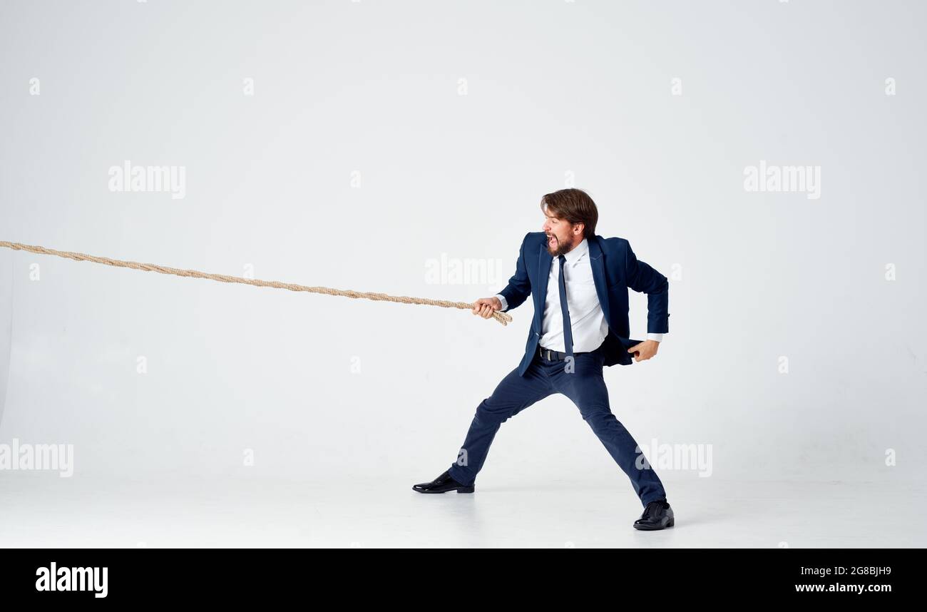 business man in suit pulling rope Studio team work Stock Photo - Alamy