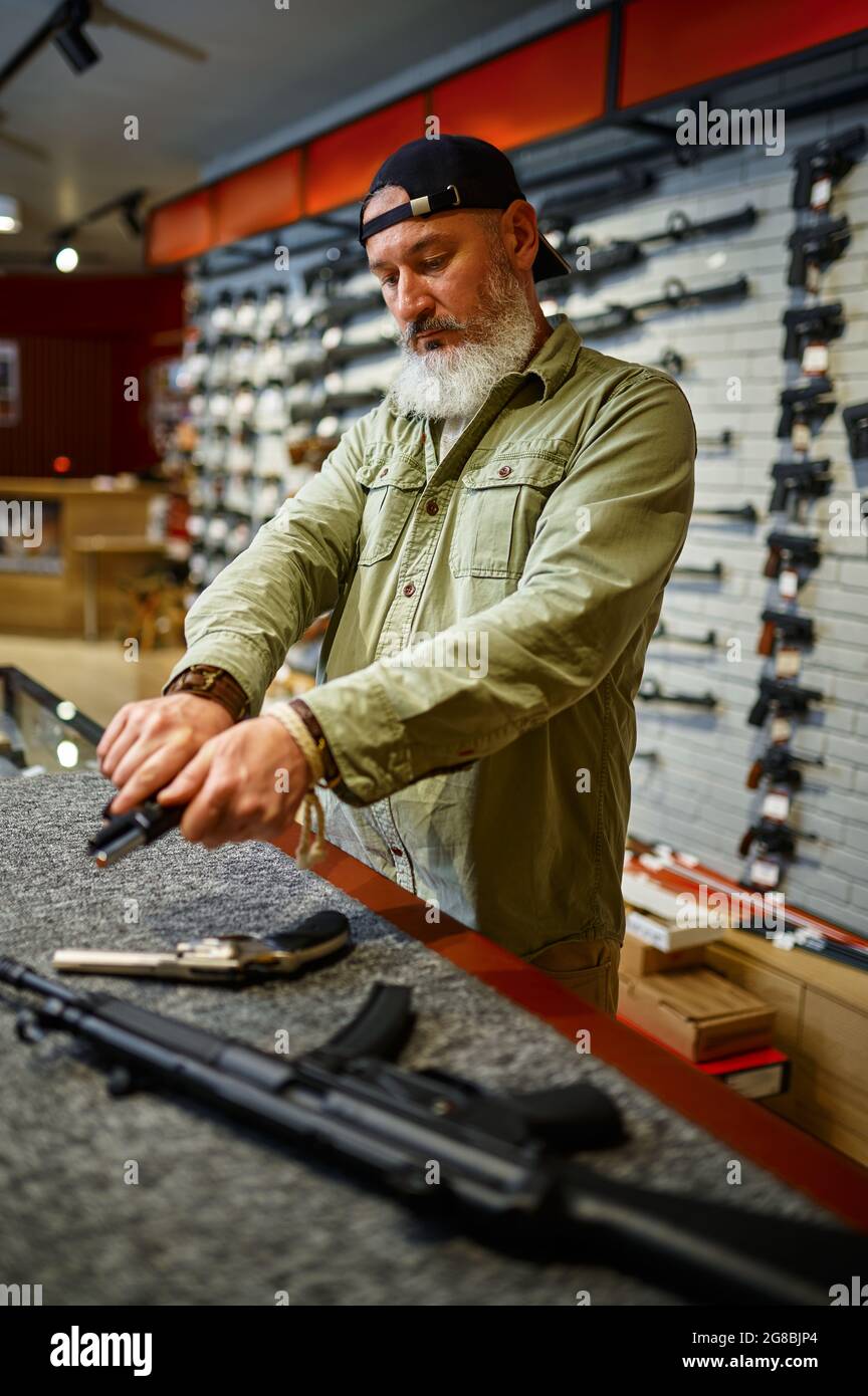 Man reload handgun at the counter in gun store Stock Photo - Alamy