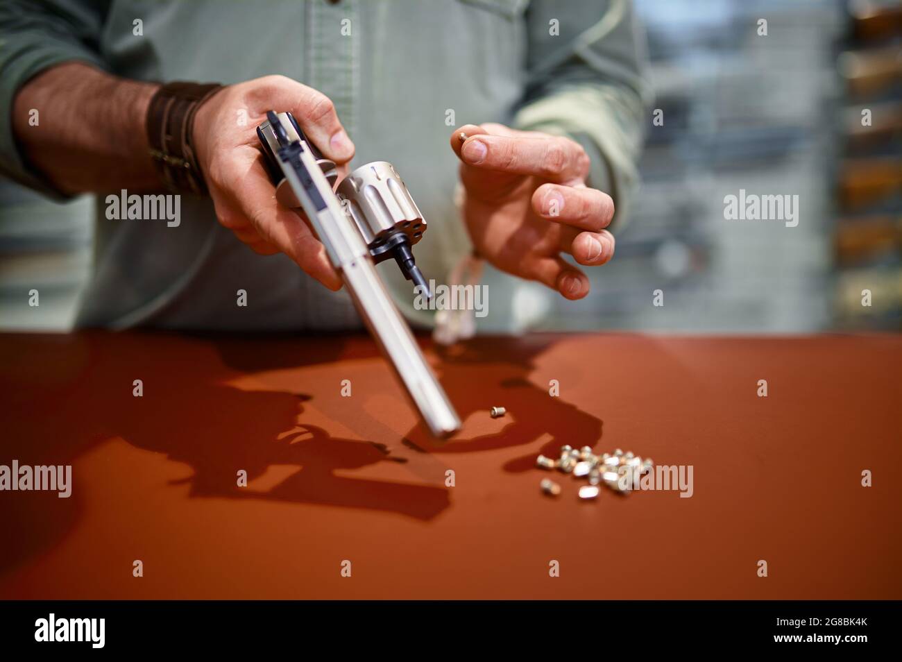 Man reload revolver at the counter in gun store Stock Photo - Alamy