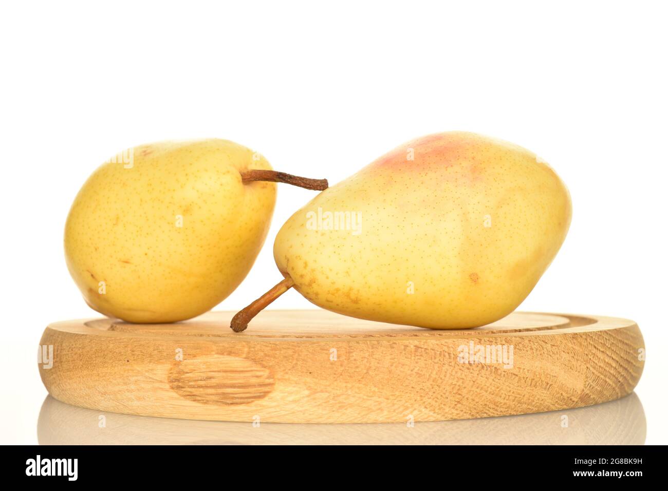 Three natural yellow pears on a wood board, close-up, isolated on white ...