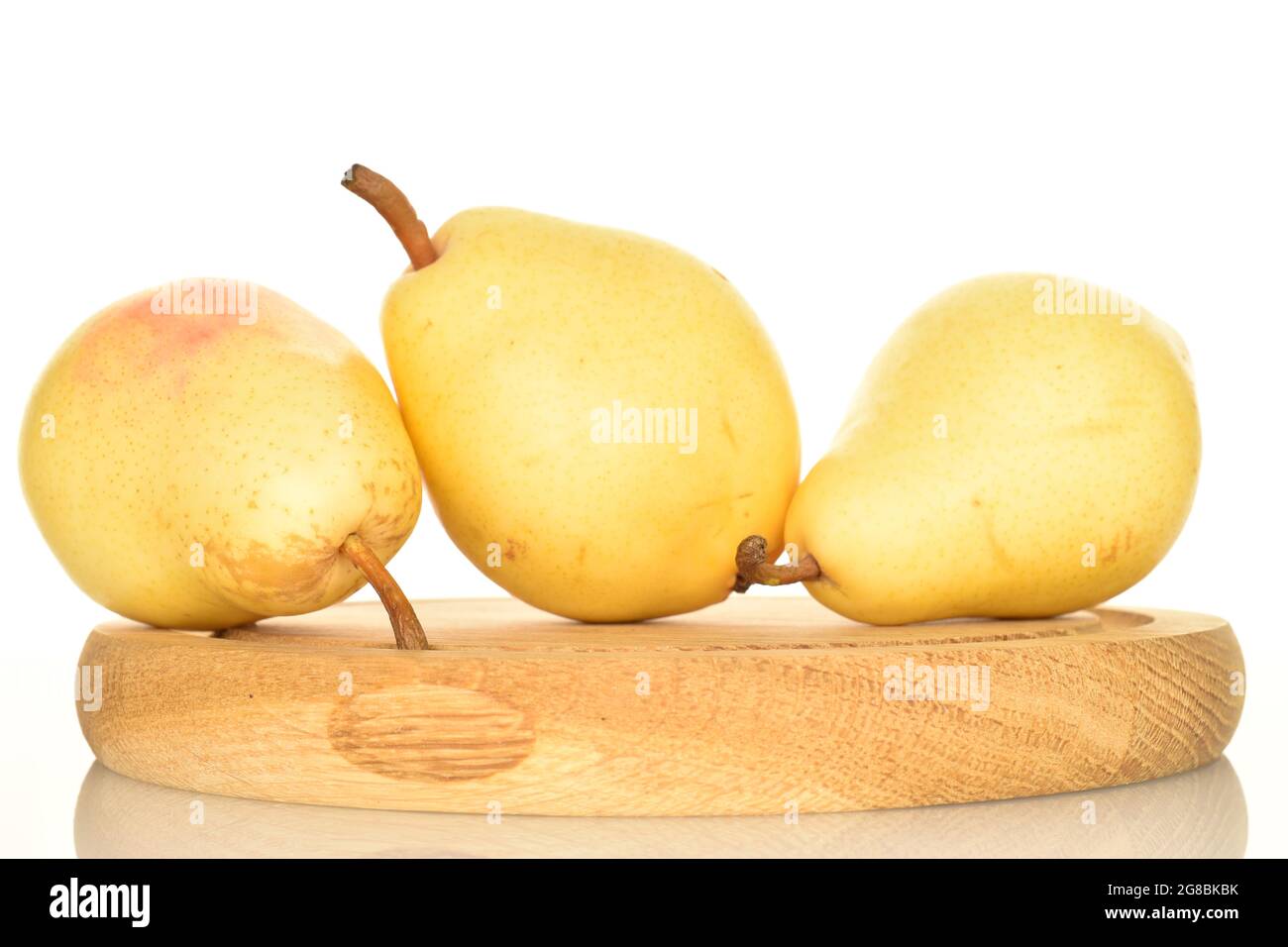 Three natural yellow pears on a wood board, close-up, isolated on white ...