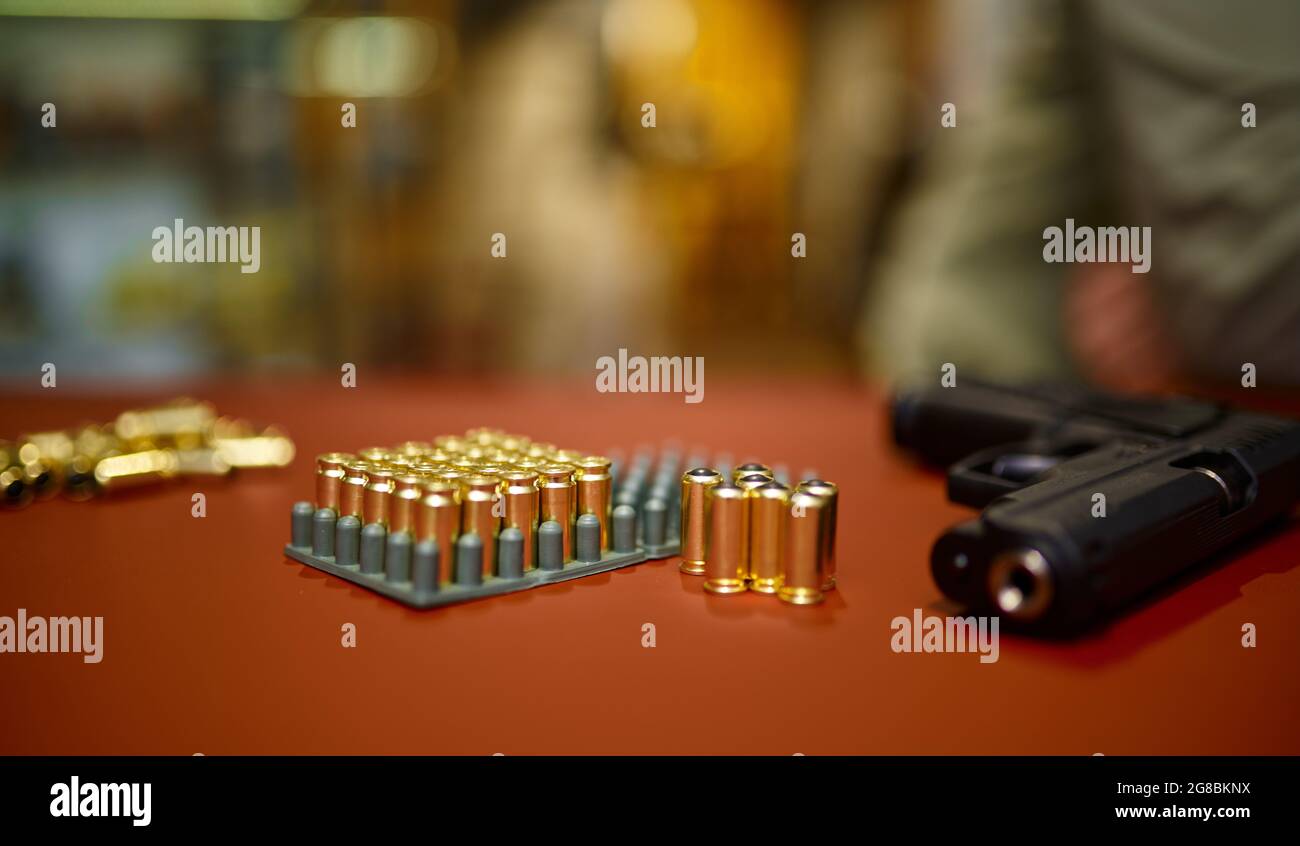 Pistol bullets in stand on counter in gun store Stock Photo - Alamy